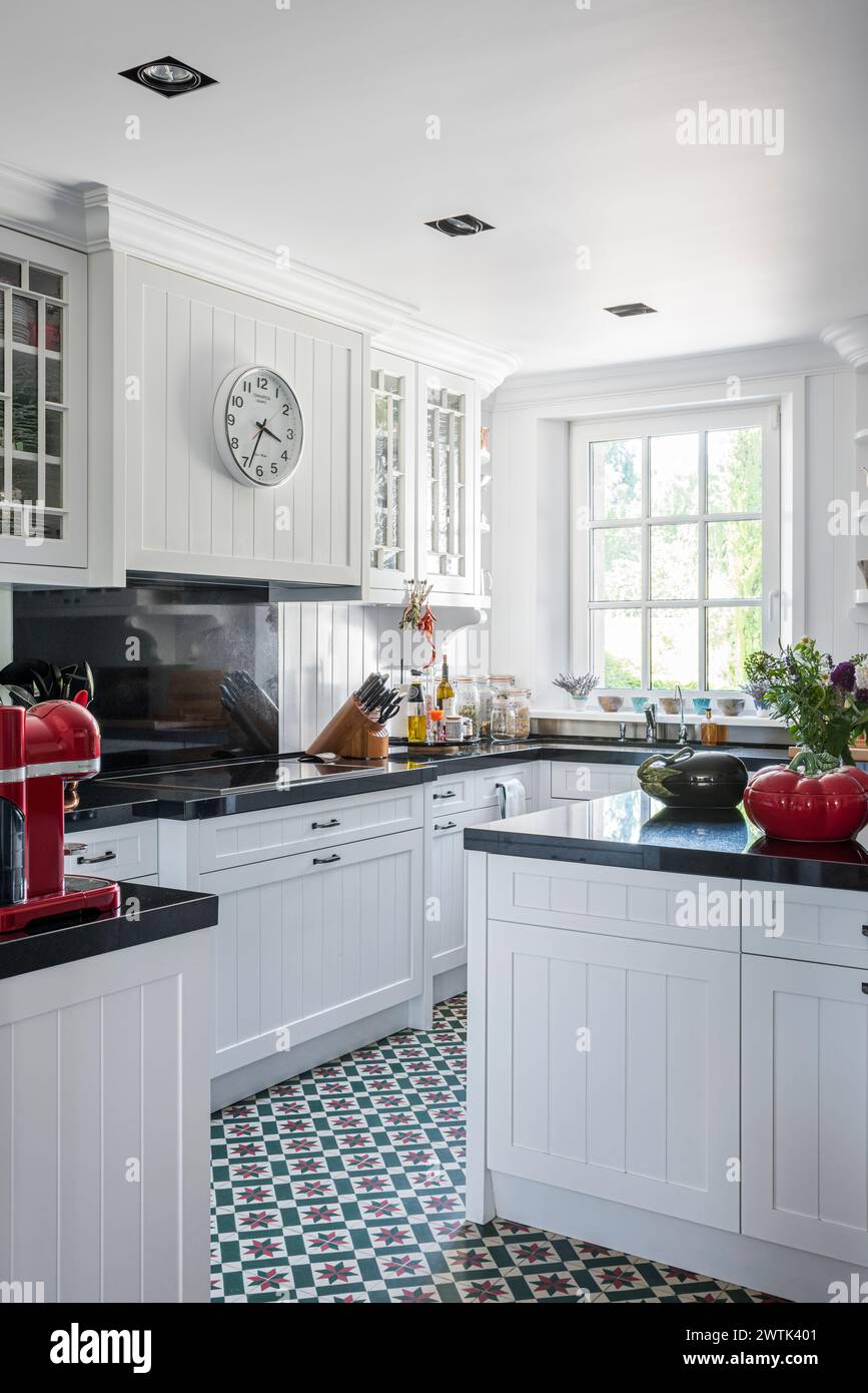 Modern white fitted kitchen with clock in Irish home, Greystones ...
