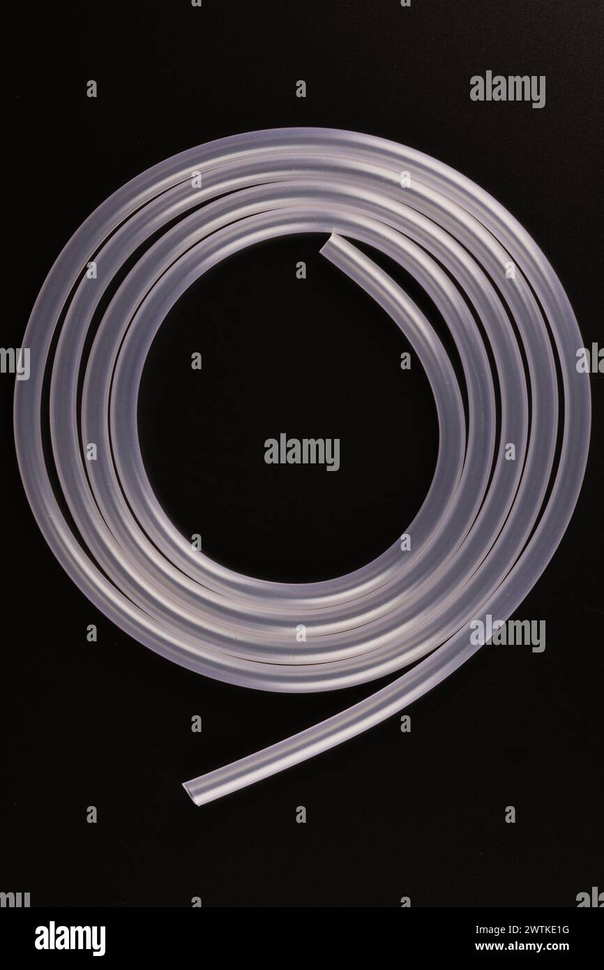 transparent plastic tube coil on black background Stock Photo - Alamy