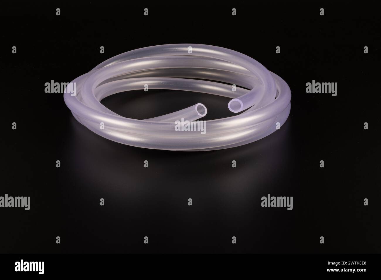 transparent plastic tube coil on black background Stock Photo - Alamy