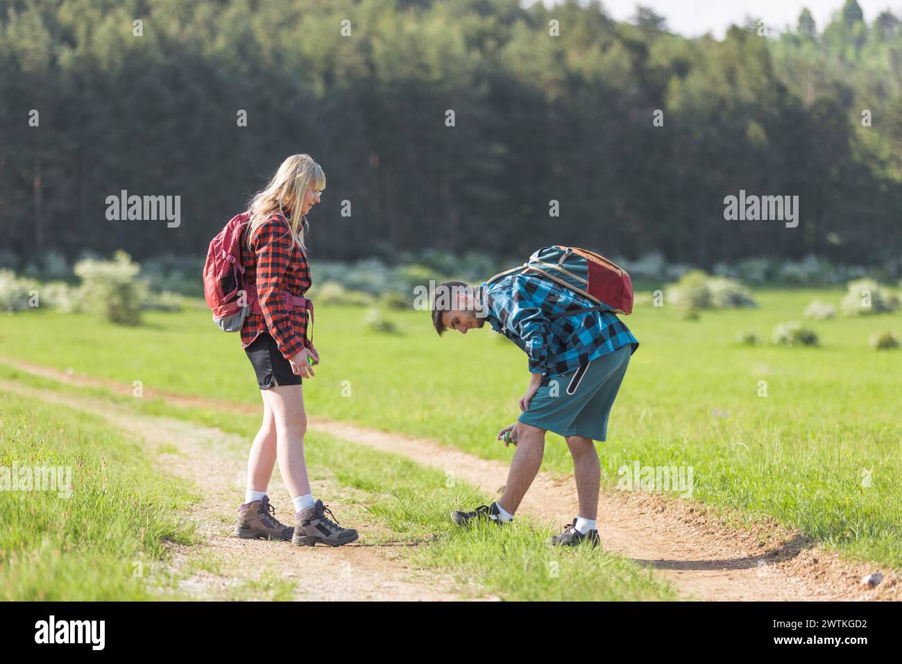 Man and woman spraying with tick repellent while hiking in Infected ...