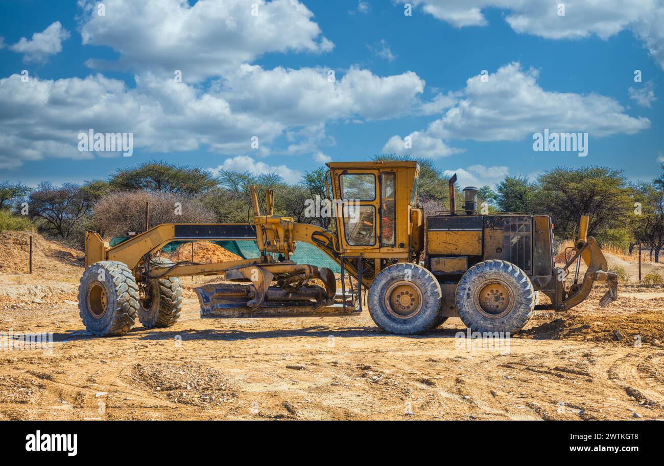 yellow grader digging the earth on a construction site at a diamond ...