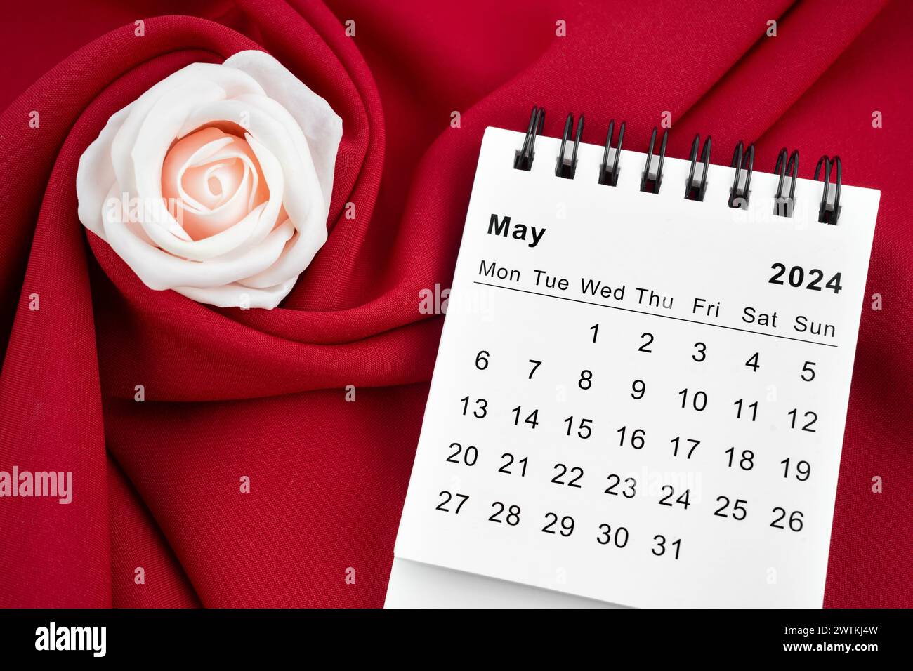 May 2024 desk calendar and pink rose on red textile background Stock ...