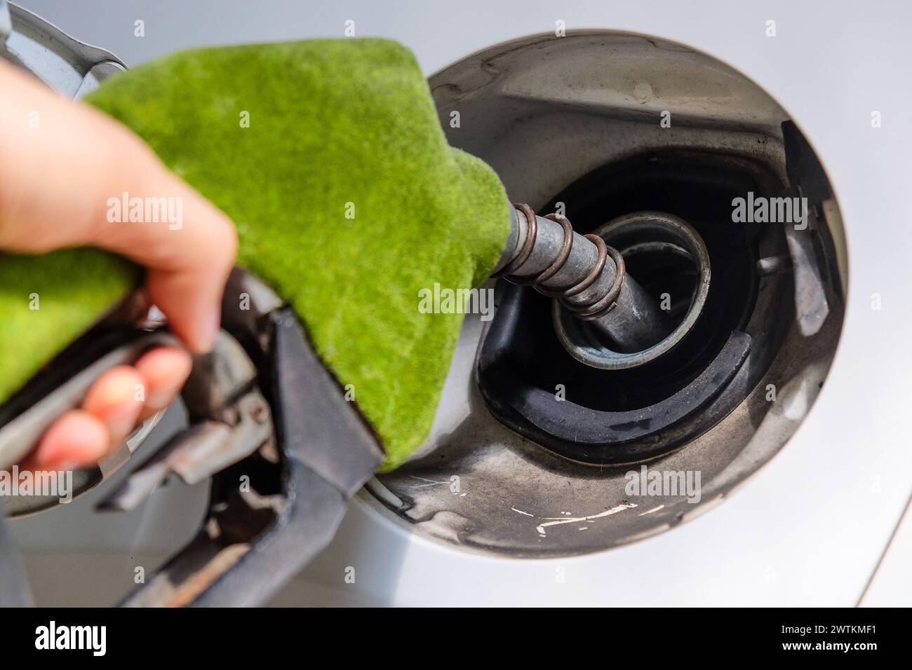 Close up image of hand refilling a car with fuel at a gas station ...