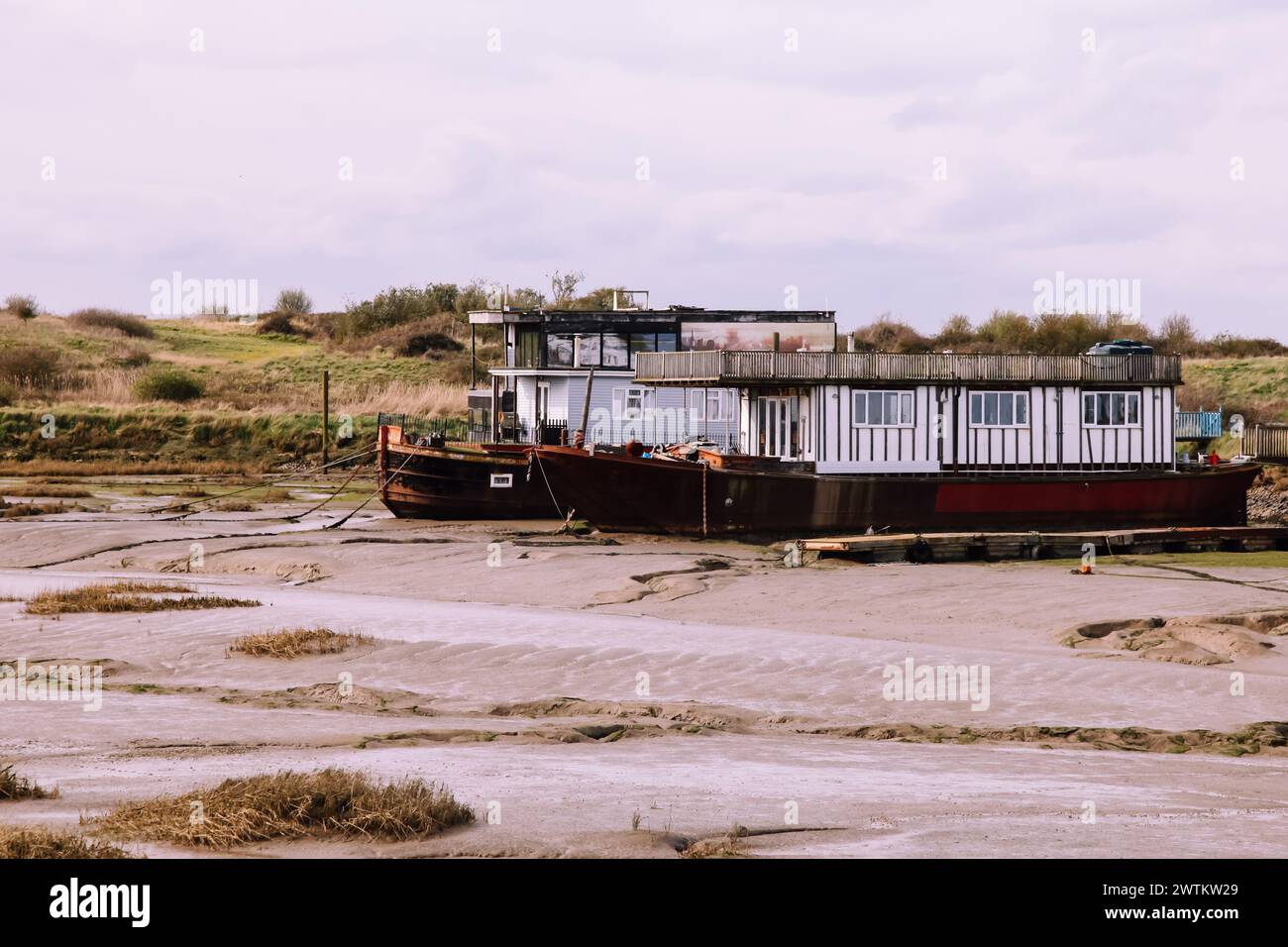 Boats moored in mud tide out Wakering Boatyard, Great Wakering, Essex ...