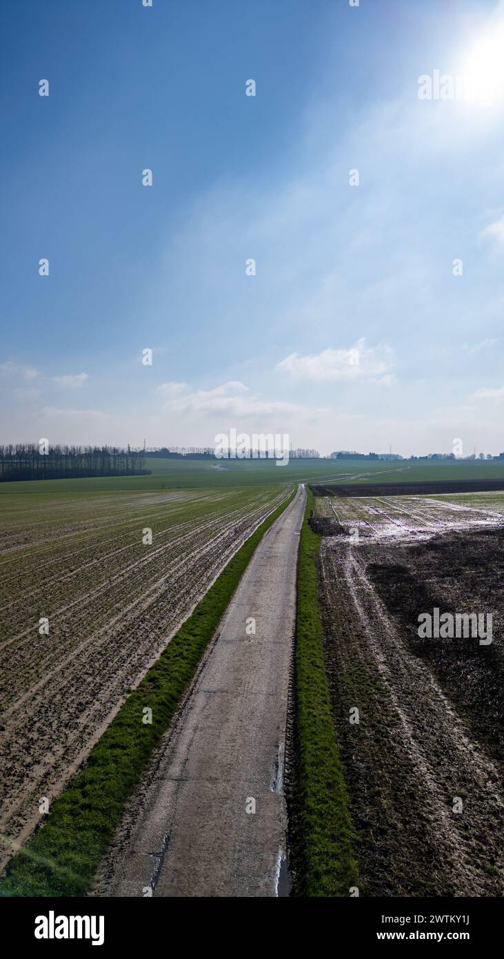 This vertical aerial image captures the straight stretch of a narrow ...