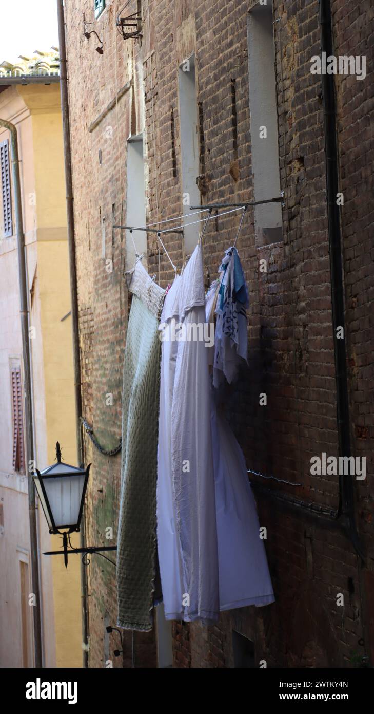 clothes hung on a window clothesline in a house in italy Stock Photo - Alamy