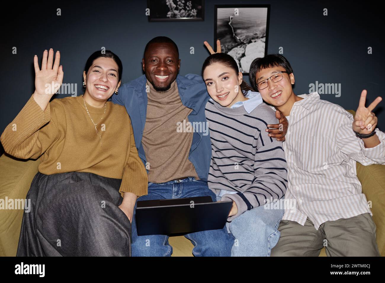 Portrait of carefree multiethnic business team waving at camera while ...