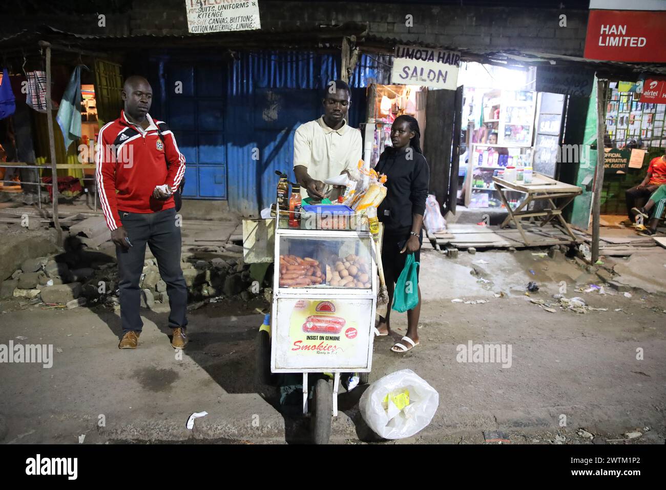 A hawker serves her customers late at night in Kibera Slum, Nairobi ...