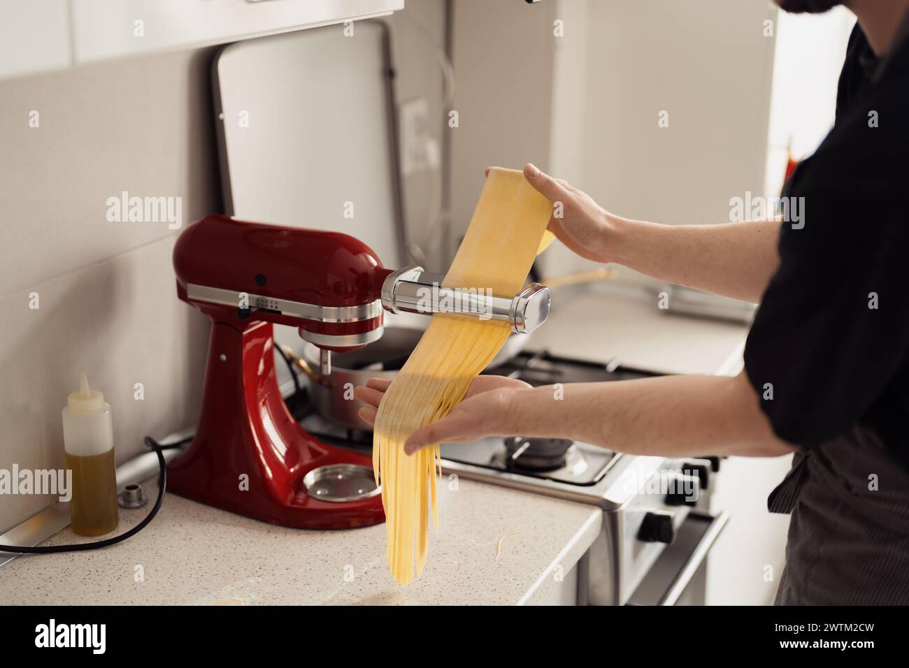 Making fresh pasta dough with red stand mixer in kitchen Stock Photo ...