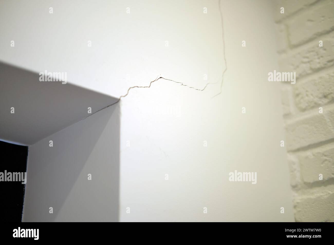 Cracked walls inside a house in an apartment, white wall with a crack ...