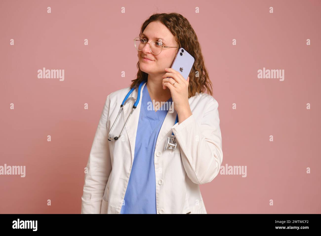 Woman doctor holding Apple iPhone mobile phone in her hands, studio ...