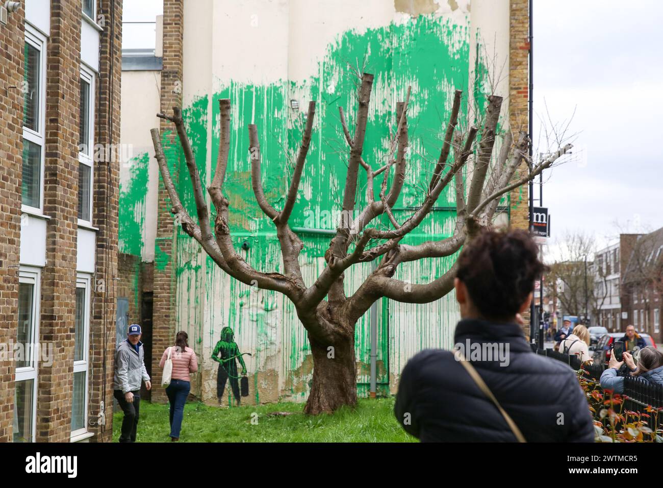 London, UK. 18th Mar, 2024. A woman looks at Banksy art in Finsbury ...