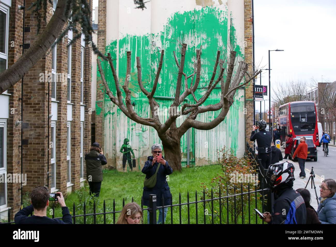 London, UK. 18th Mar, 2024. People gather to take photographs of Banksy ...