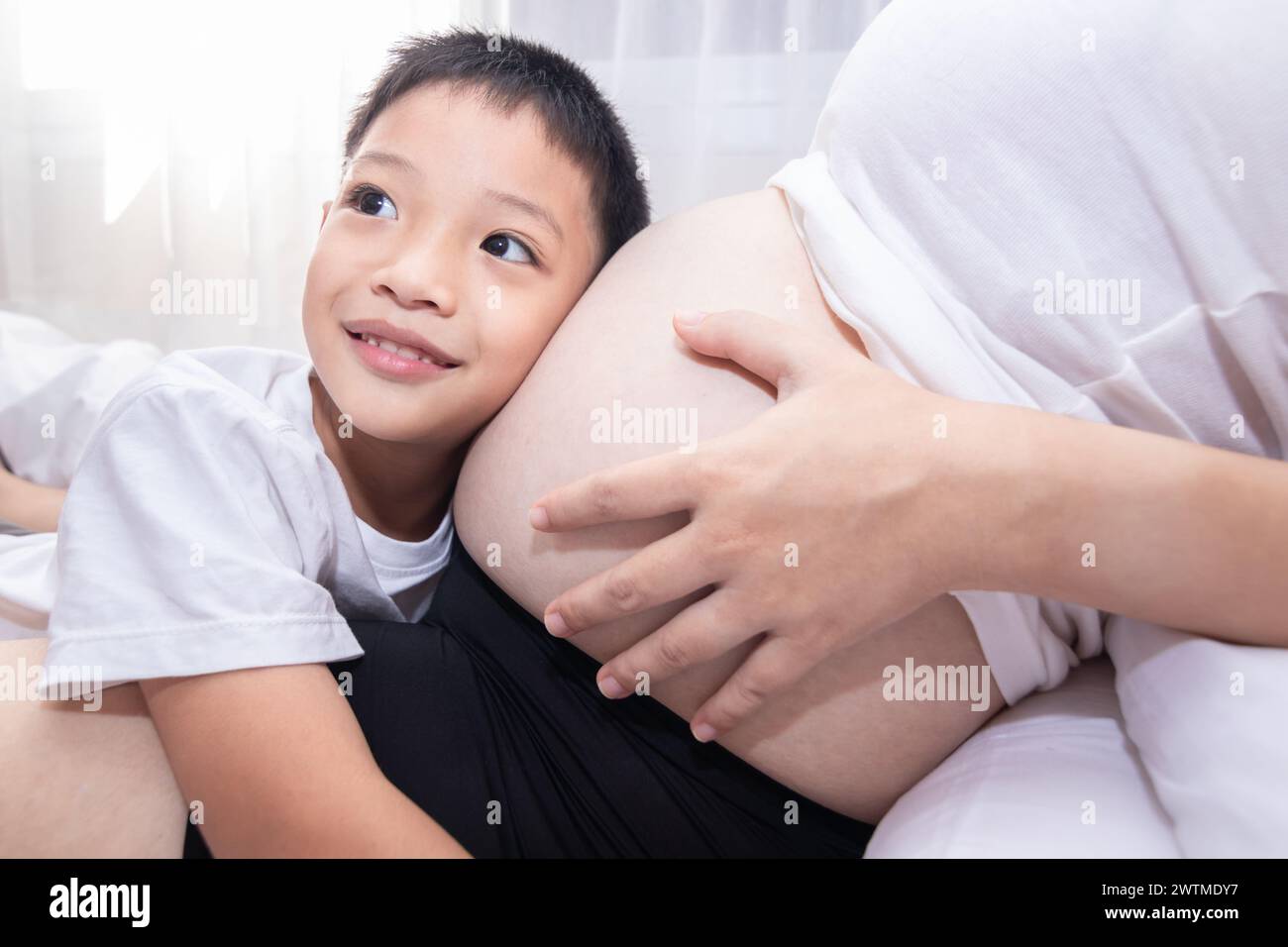 little child holding the belly of a pregnant mother. Pregnant mother ...