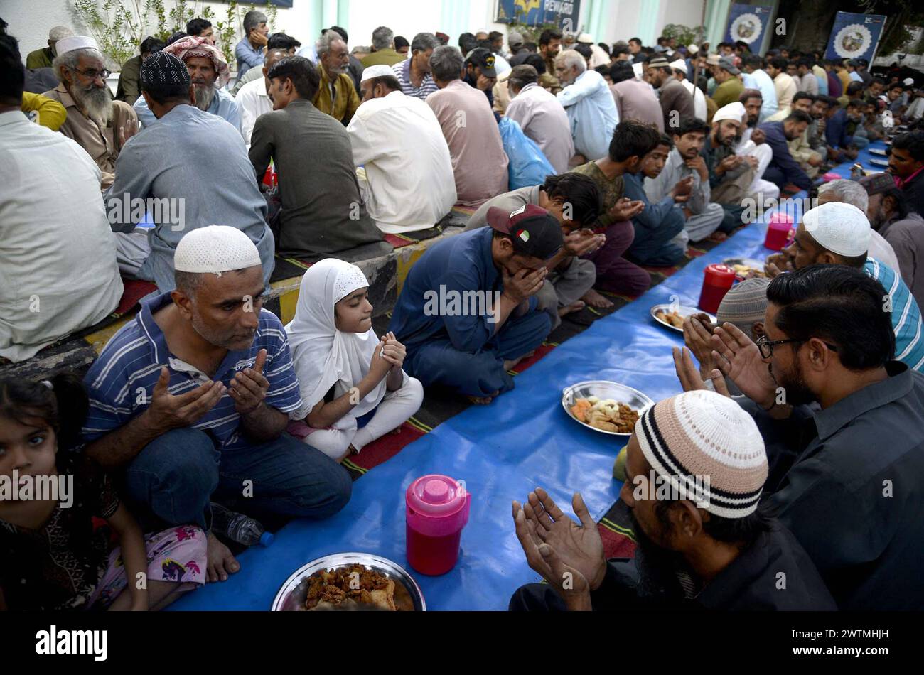 Faithful Muslims are breaking the fast (Iftar) under the supervision of charitable organization ...