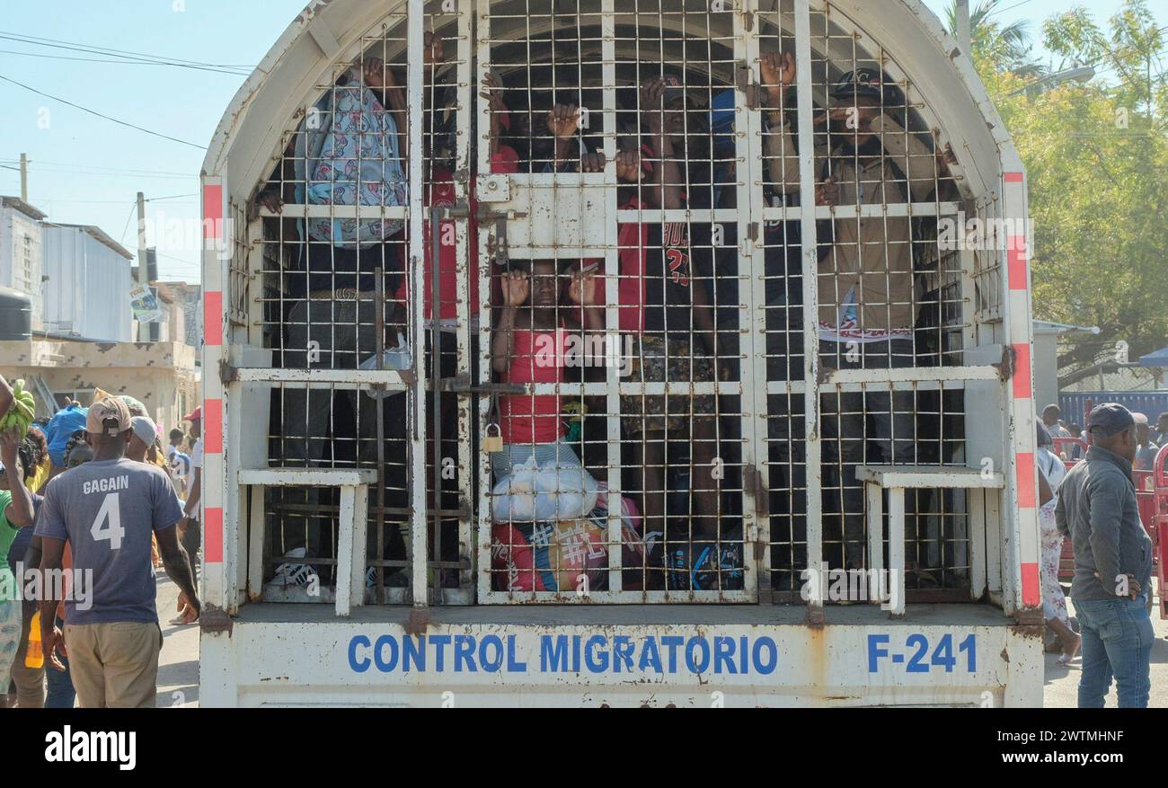 People who were detained for deportation to Haiti stand inside a police ...