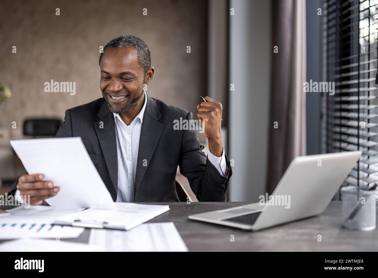 Happy diverse male raising hand with clenched fist while looking at ...