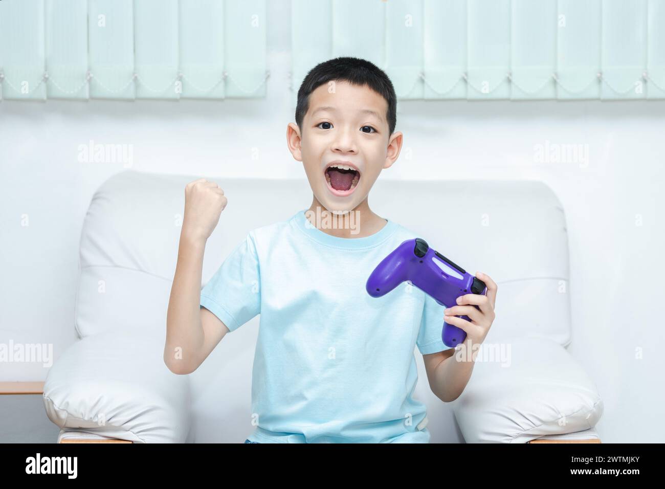 little Asian boy playing a video game. shot of a child holding a game ...