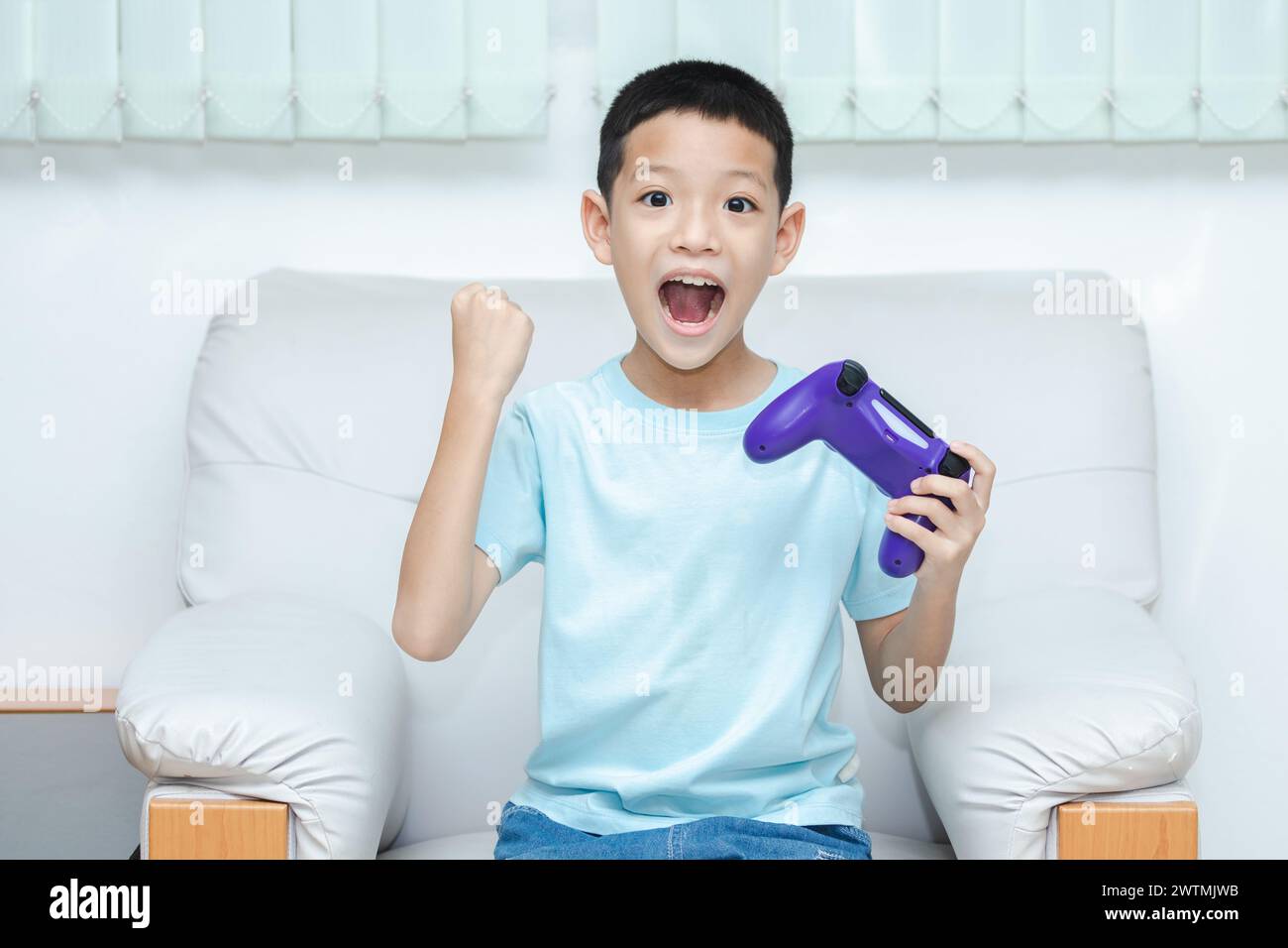 little Asian boy playing a video game. shot of a child holding a game ...