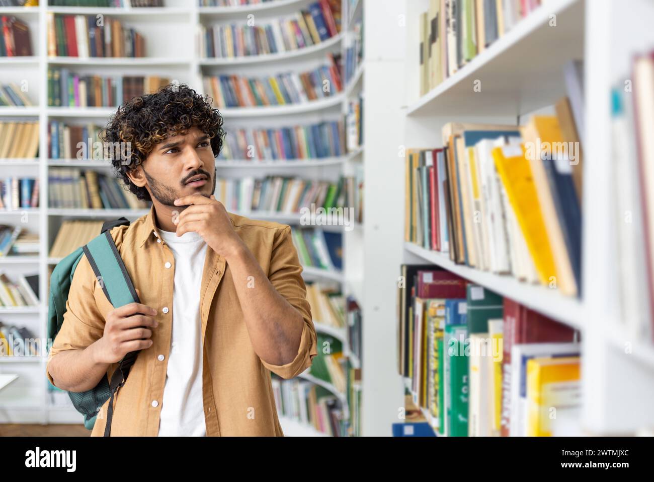 Thoughtful arab customer with backpack on one shoulder holding chin ...