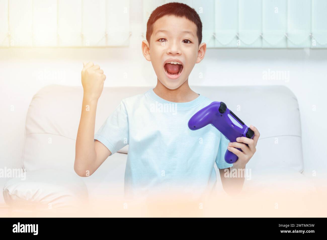 little Asian boy playing a video game. shot of a child holding a game ...