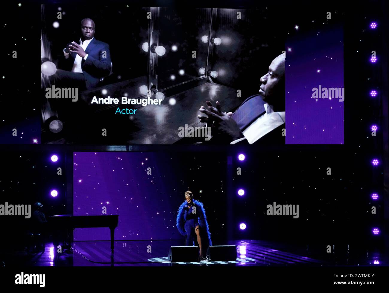 Singer Andra Day performs under an image of the late actor Andre ...