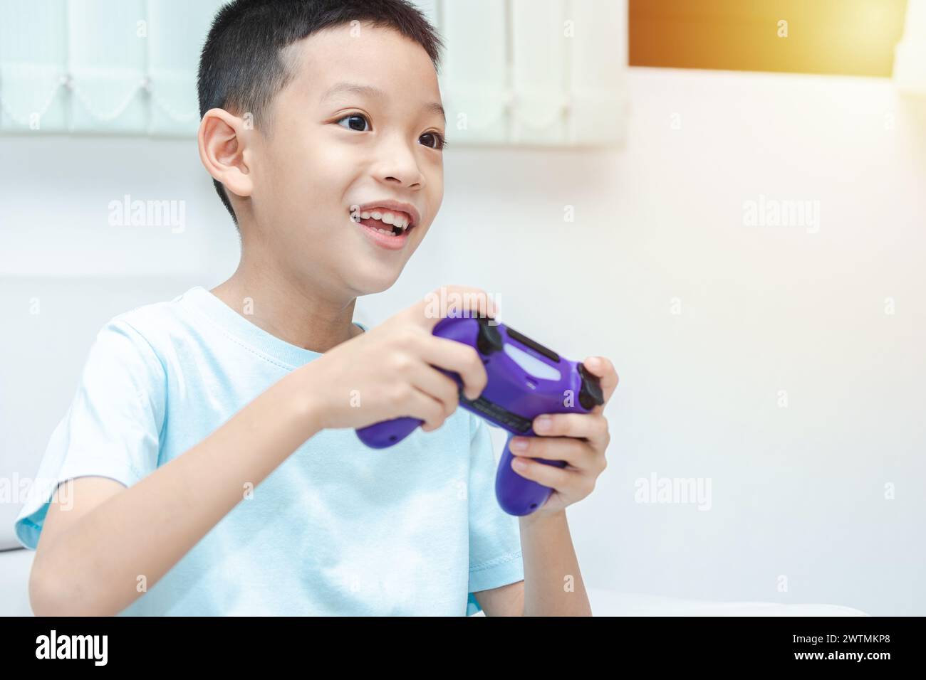 little Asian boy playing a video game. shot of a child holding a game ...