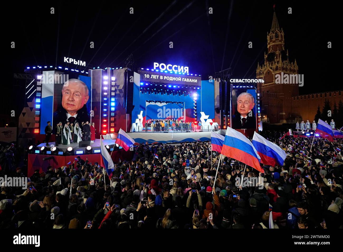 Russian President Vladimir Putin is seen on the screens as he attends a ...