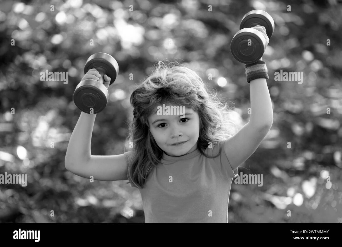 Kids sport. Boy is doing exercises to develop muscles. Child is doing ...