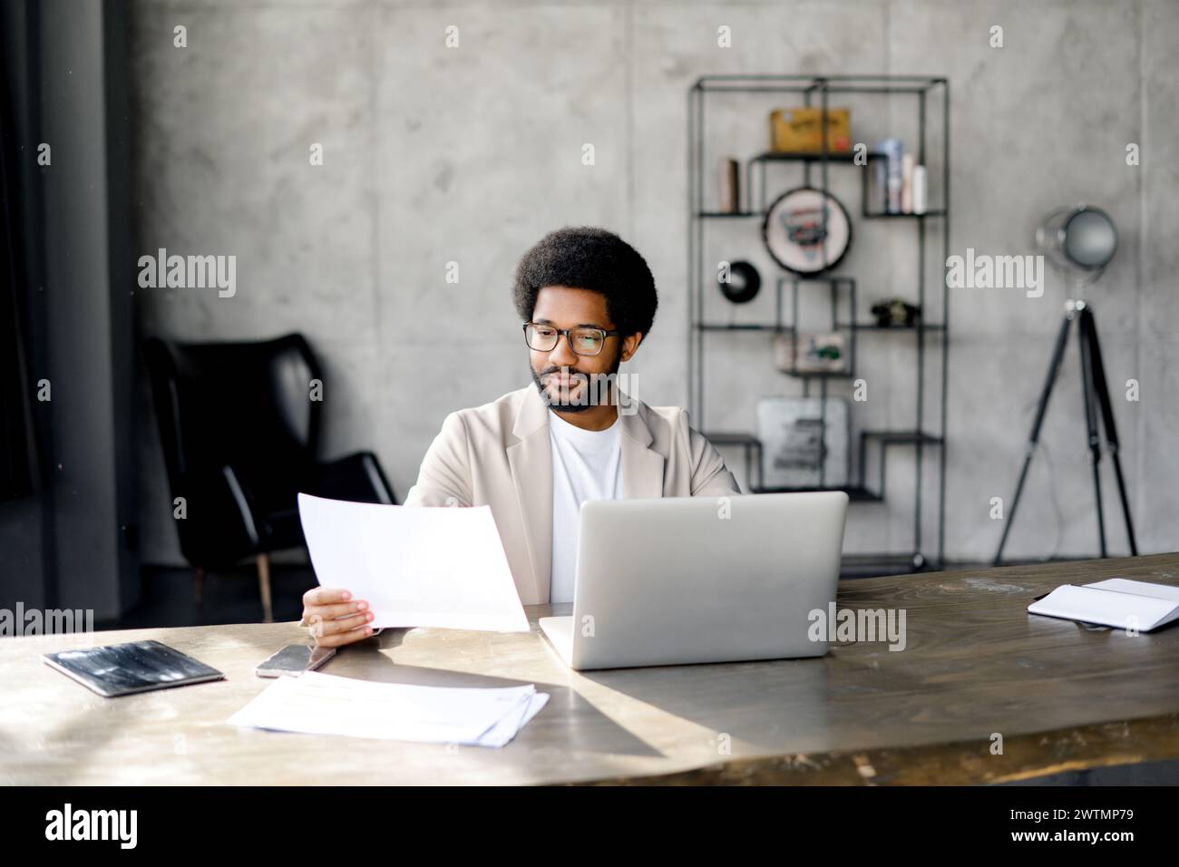 A young Brazilian businessman is focused on reading a document at his ...