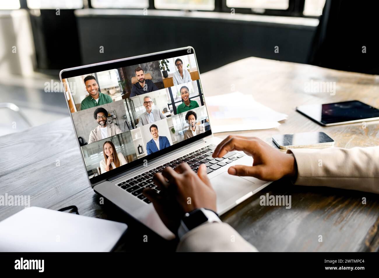 Young entrepreneur is shown in the midst of a cheerful virtual meeting ...