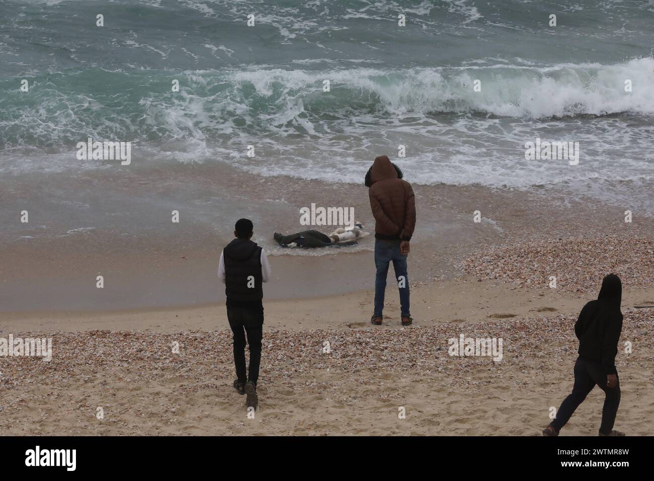 Palestinians prepare to bury a body on the beach near the Nuseirat ...