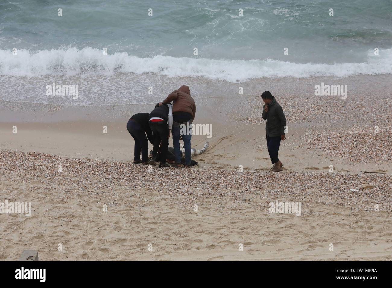 Palestinians prepare to bury a body on the beach near the Nuseirat ...
