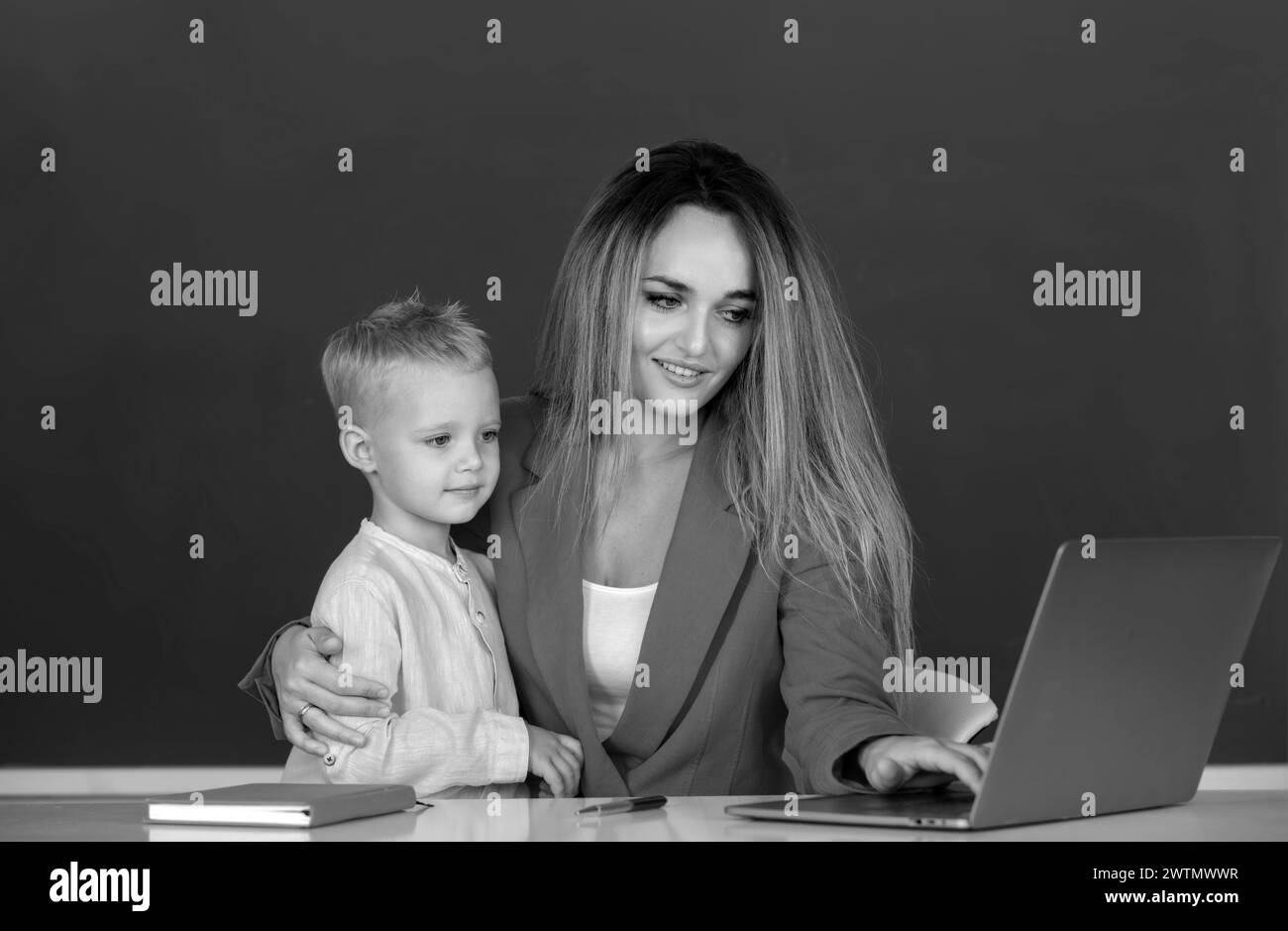Mother and son learning. Teacher helping elementary school pupils in ...