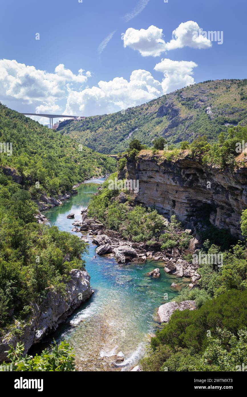 A serene river flows through a dramatic canyon, surrounded by lush ...