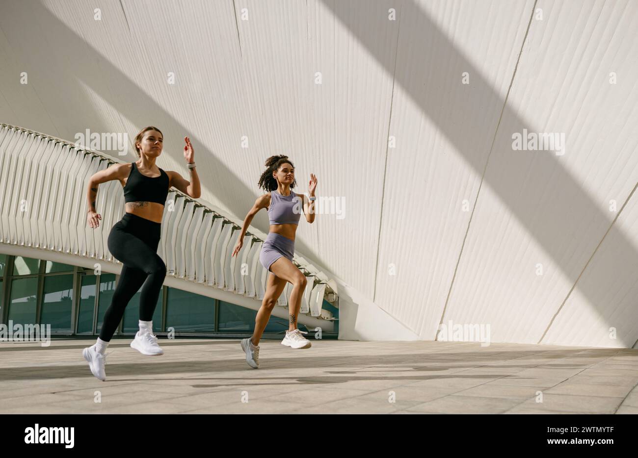Active women athlete running side by side along an outdoor track on ...