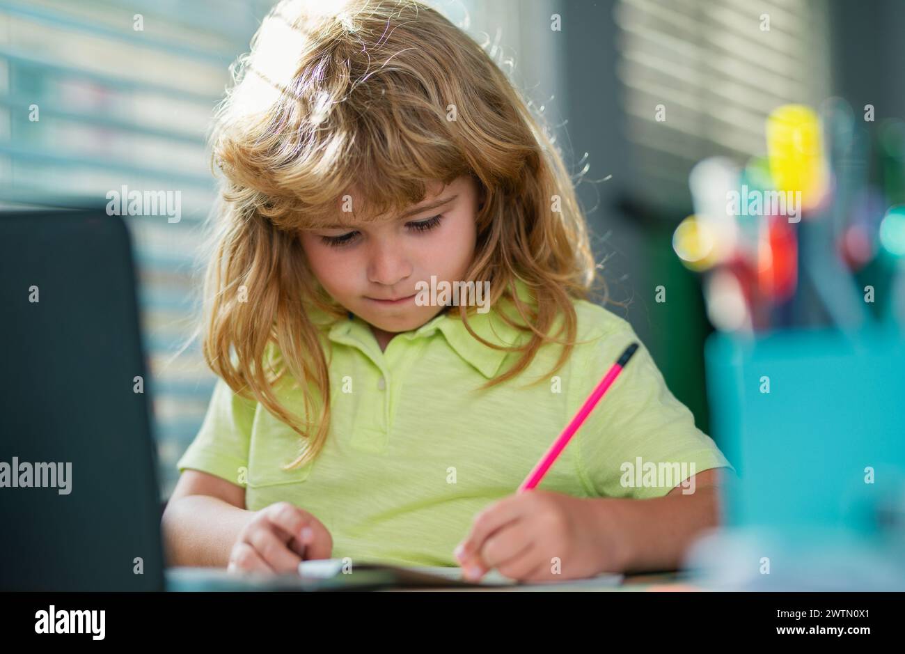 Serious school child writing homework in school class. Portrait of ...
