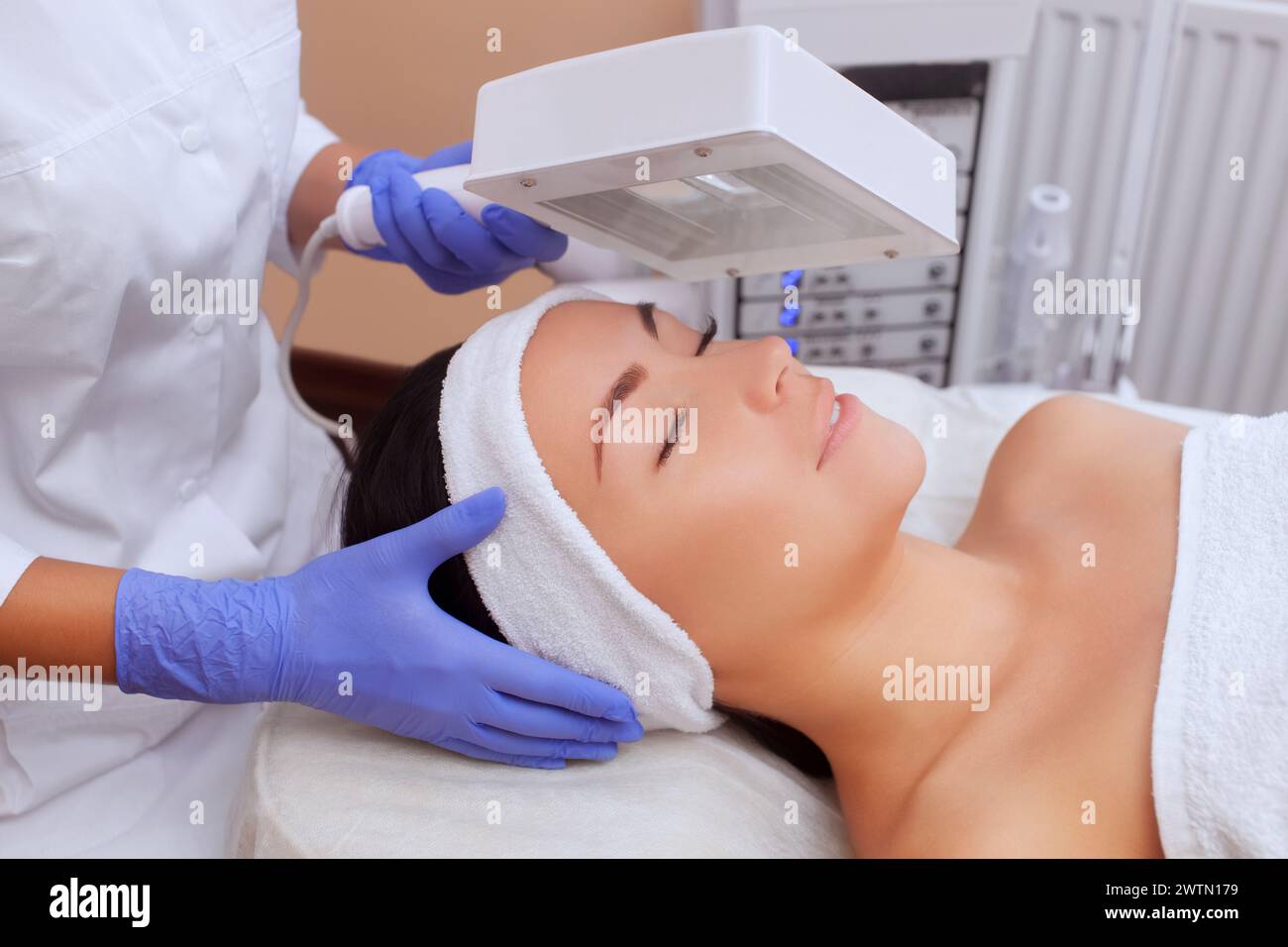 The cosmetologist uses the Wood Lamp for detailed diagnosis of the skin ...