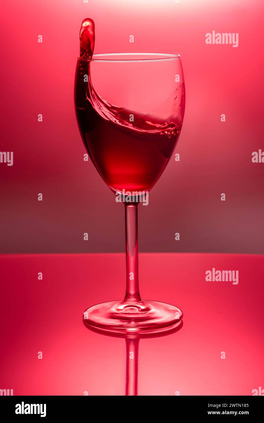 splash in a glass goblet with liquid on a colored background Stock Photo - Alamy