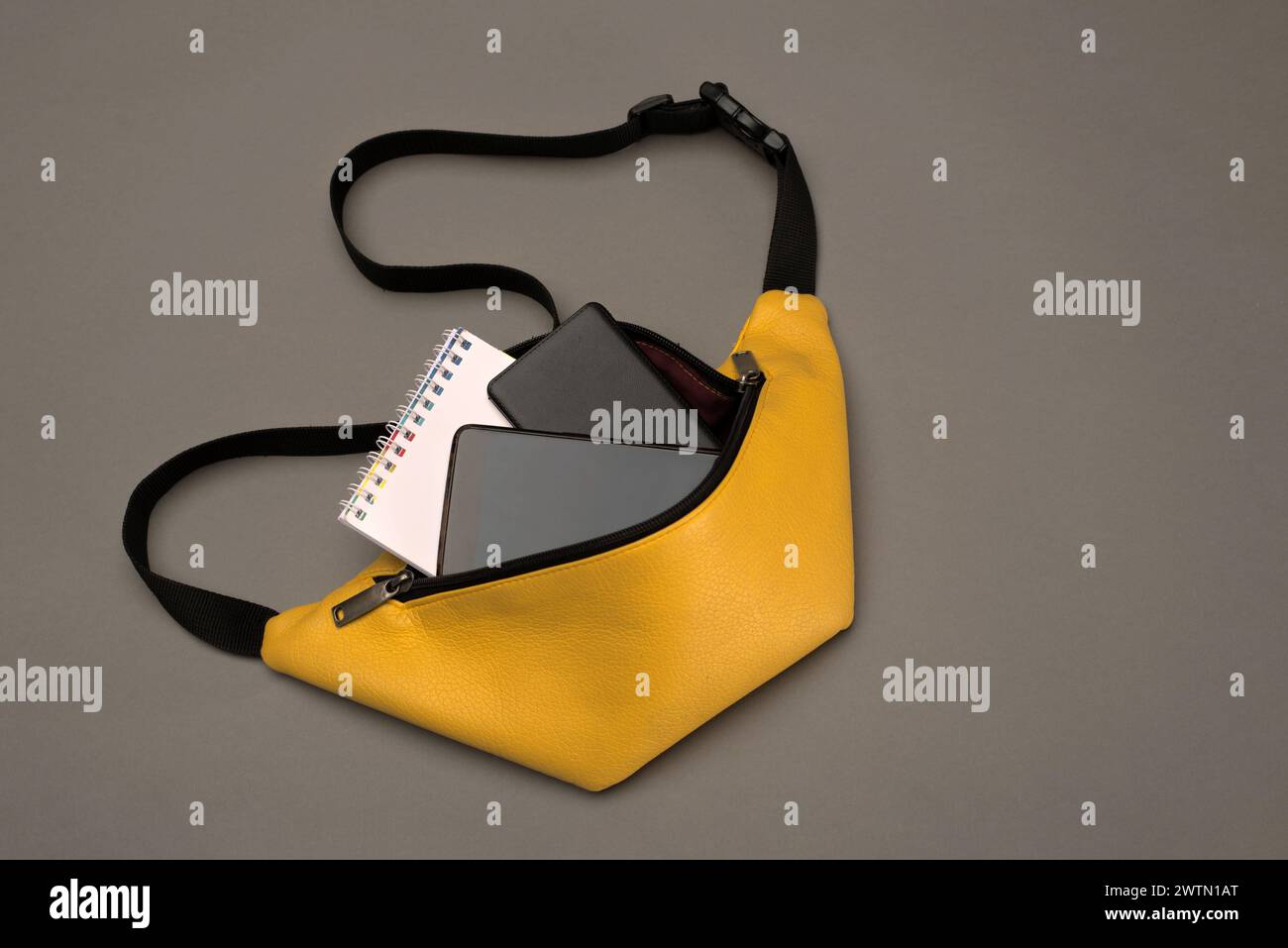 yellow belt bag for women and men on a dark gray background with ...