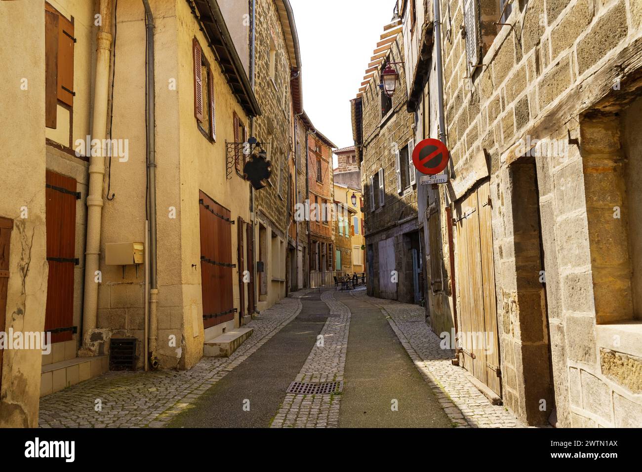 A narrow street with a stop sign positioned in the middle of it ...