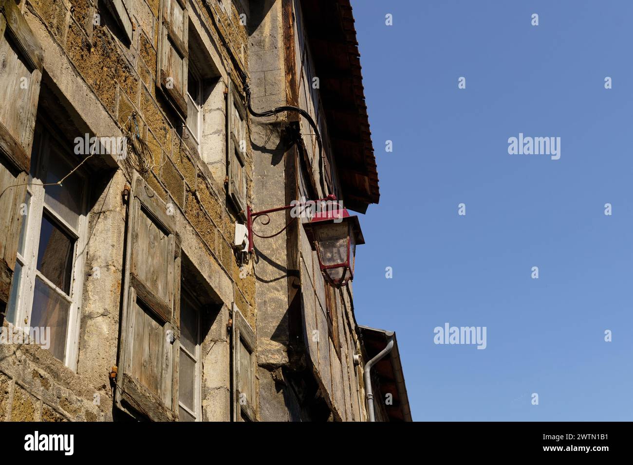 An aged building with a street light attached on the side, showcasing ...