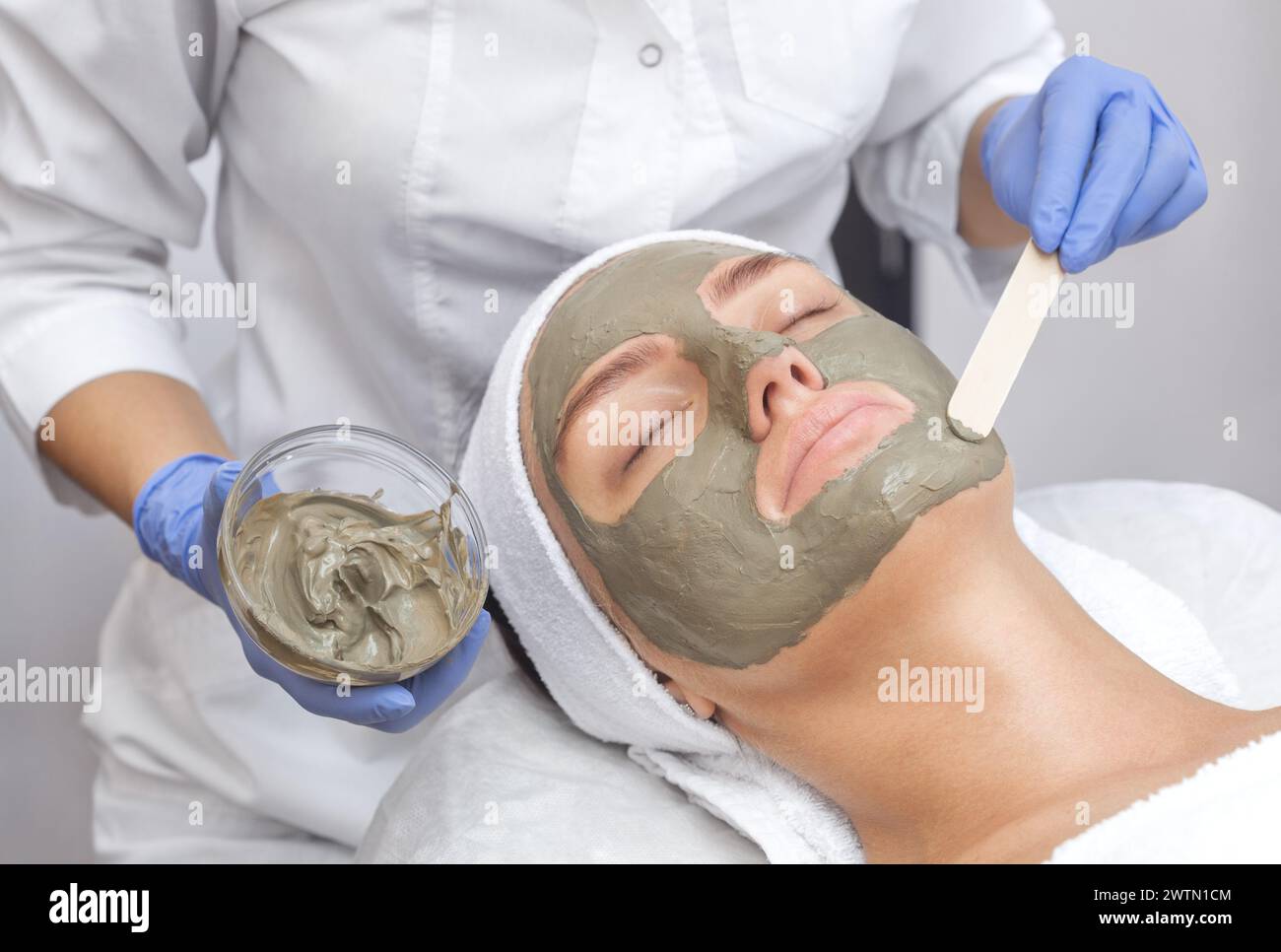 The procedure for applying a mask from clay to the face of a beautiful ...