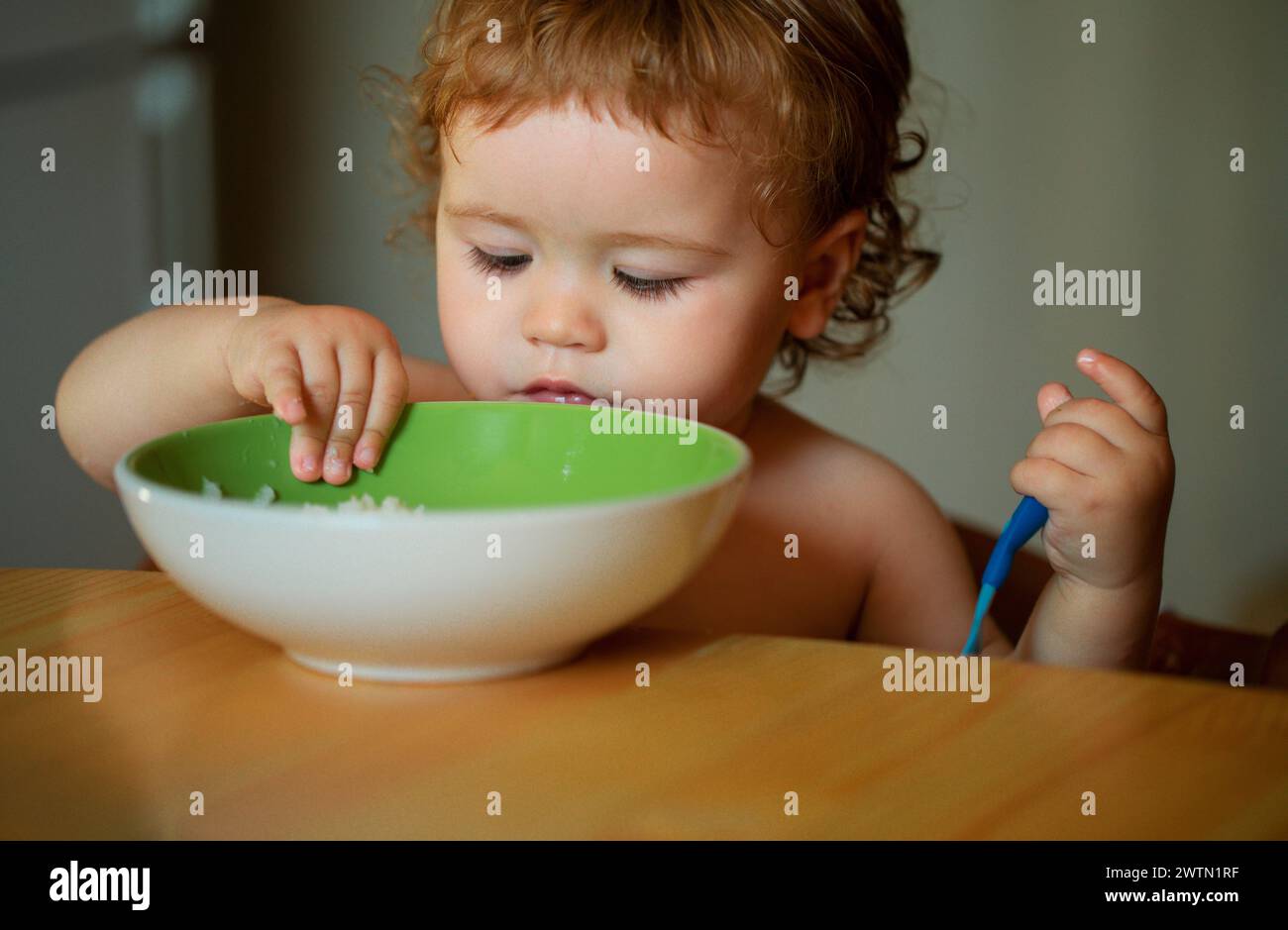 Kid baby eat soup in the kitchen with dishes and spoon Stock Photo - Alamy