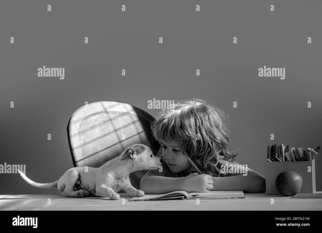 Cute child learning at home. Puppy dog helping kid with education ...