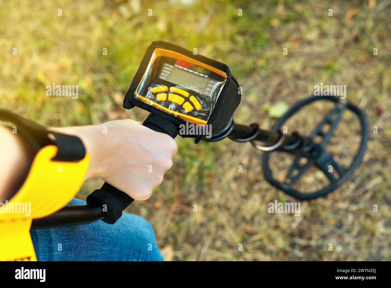 A man's hand with a metal search device. Treasure hunters. A metal ...