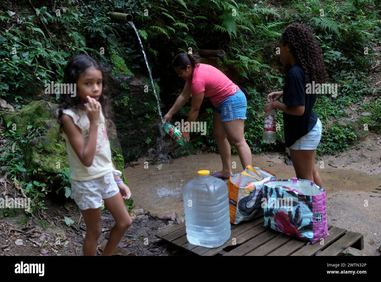 Residents collect drinking water that falls naturally down a mountain ...
