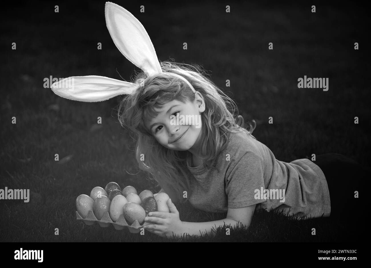 Kids boy in rabbit costume with bunny ears hunting easter eggs. Easter ...