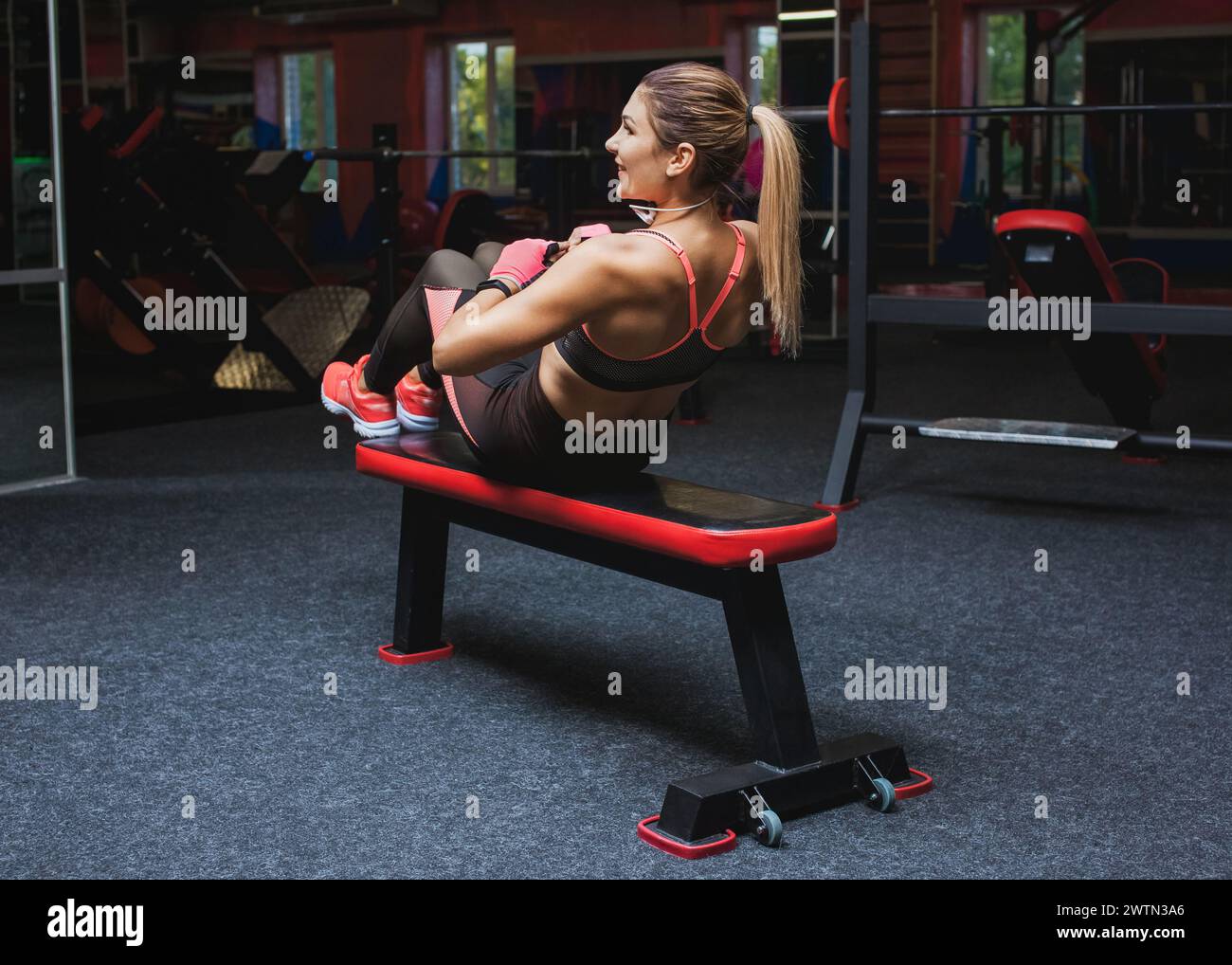 Slim, bodybuilder girl, does the exercises for press in the gym. Sports ...
