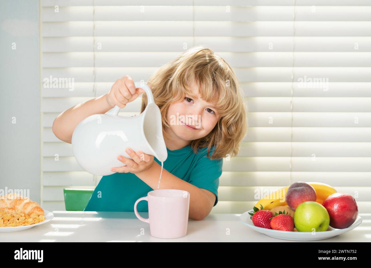 Kid boy pouring whole cows milk. Kid eating healthy food vegetables ...